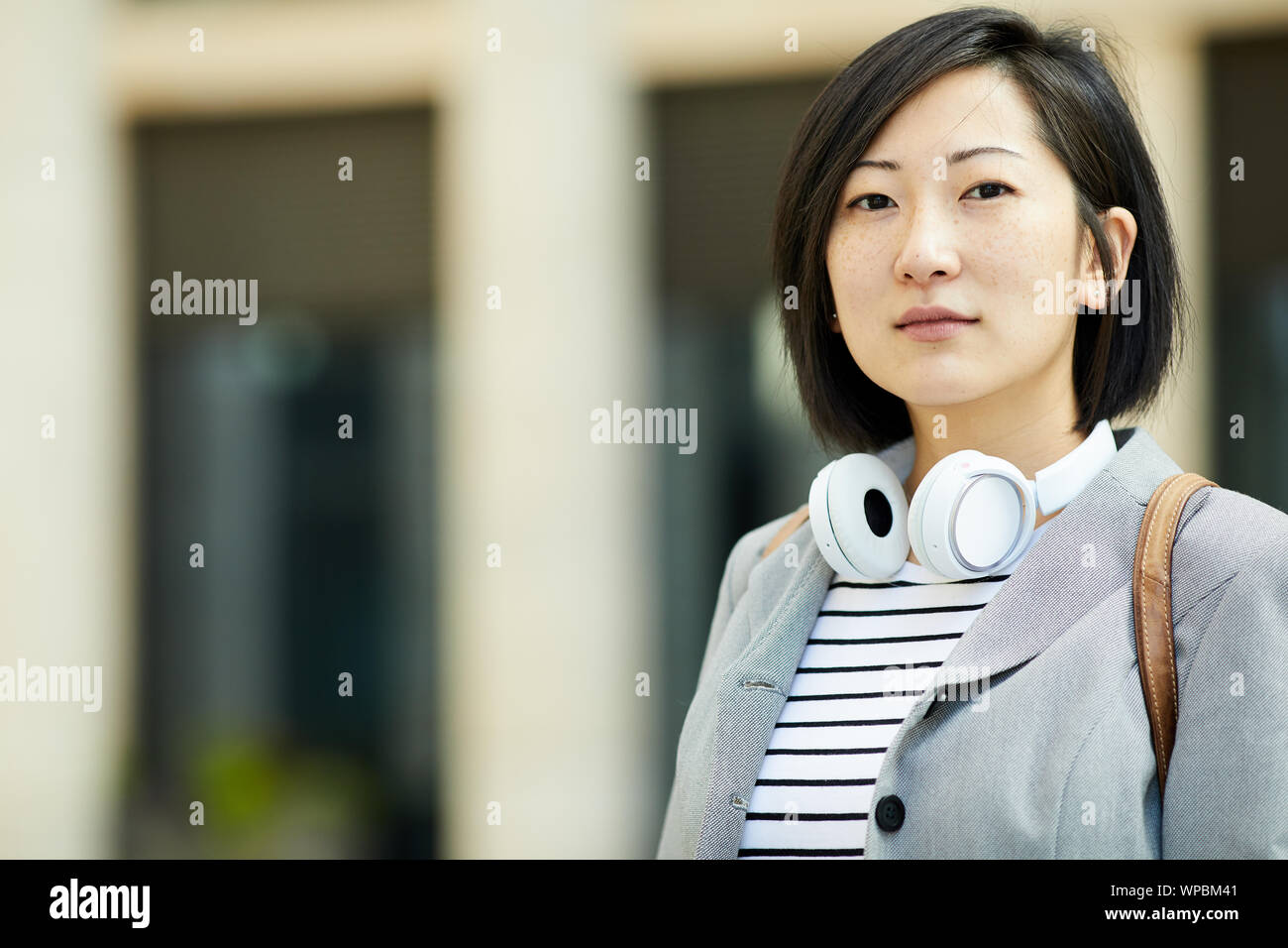 Head and shoulders portrait of modern Asian woman looking at camera ...