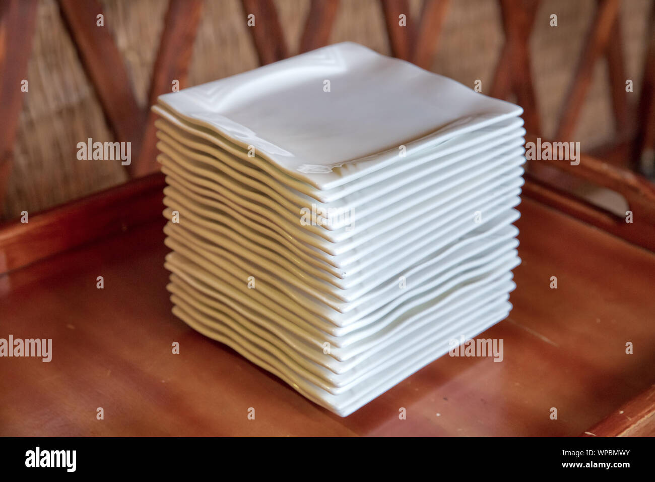 White square porcelain plates in large quantities on the counter of a ...
