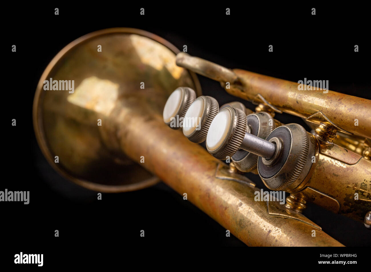 Trumpet covered with patina on a dark table. Neglected musical ...