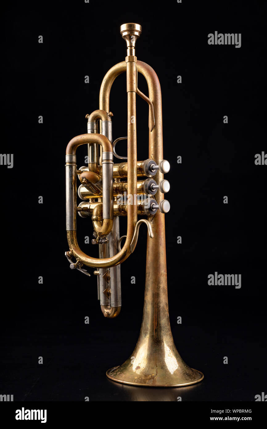 Trumpet covered with patina on a dark table. Neglected musical ...