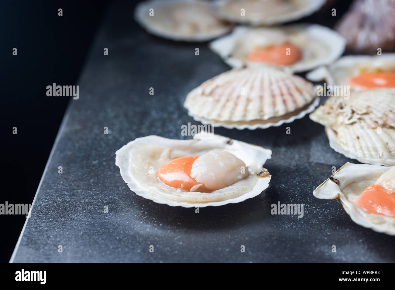 Shellfish, raw fresh scallops on black stone slate background. Seafood ...