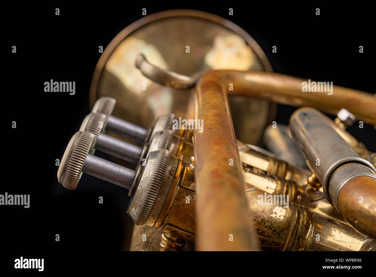 Trumpet covered with patina on a dark table. Neglected musical ...