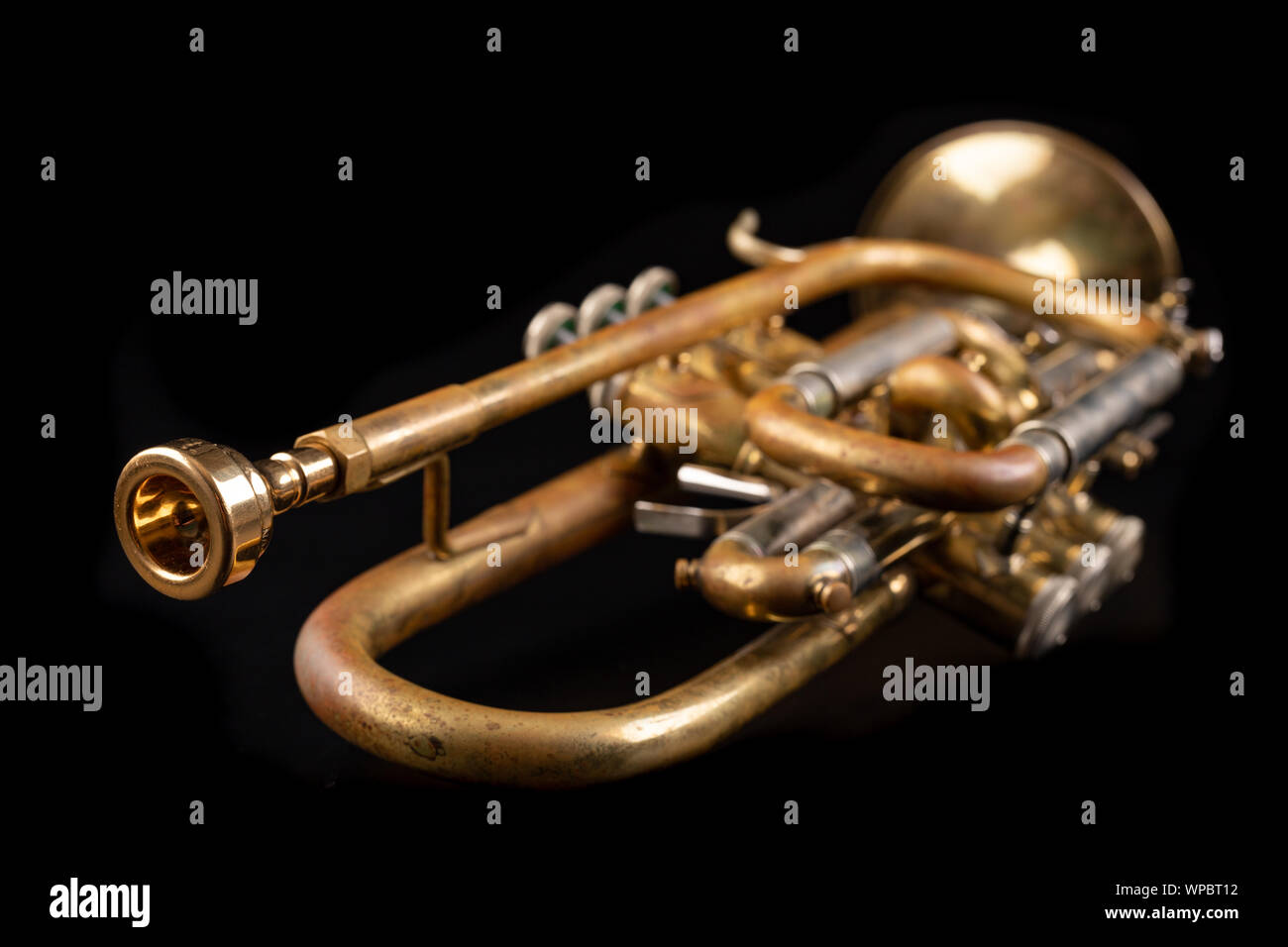 Trumpet covered with patina on a dark table. Neglected musical ...