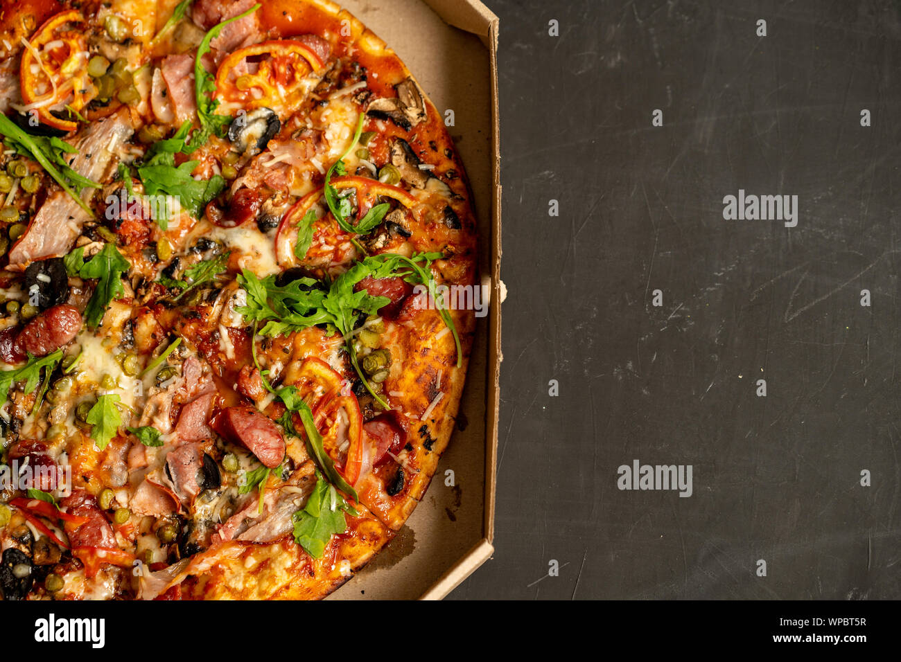 Appetizing pizza with smoked sausages bacon meat tomato cheese arugula ...