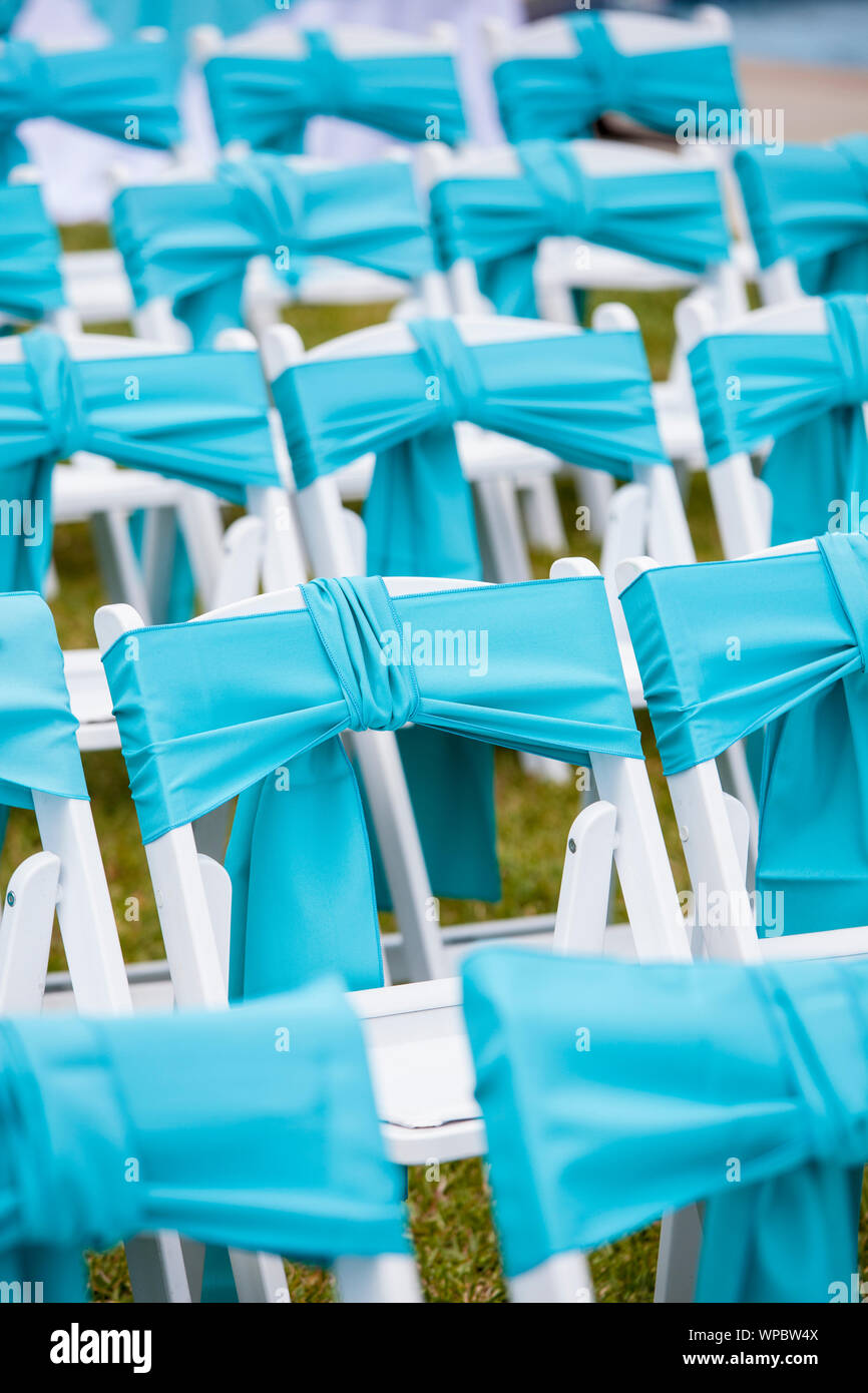 Chairs set up with ribbon for outdoor wedding Stock Photo - Alamy