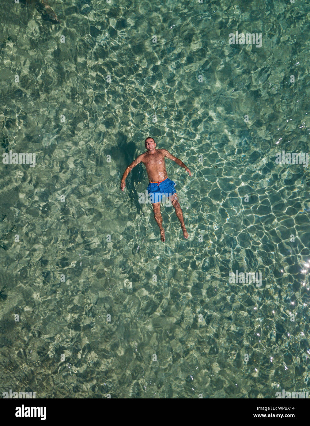 Chubby guy floating in the sea aerial Stock Photo - Alamy