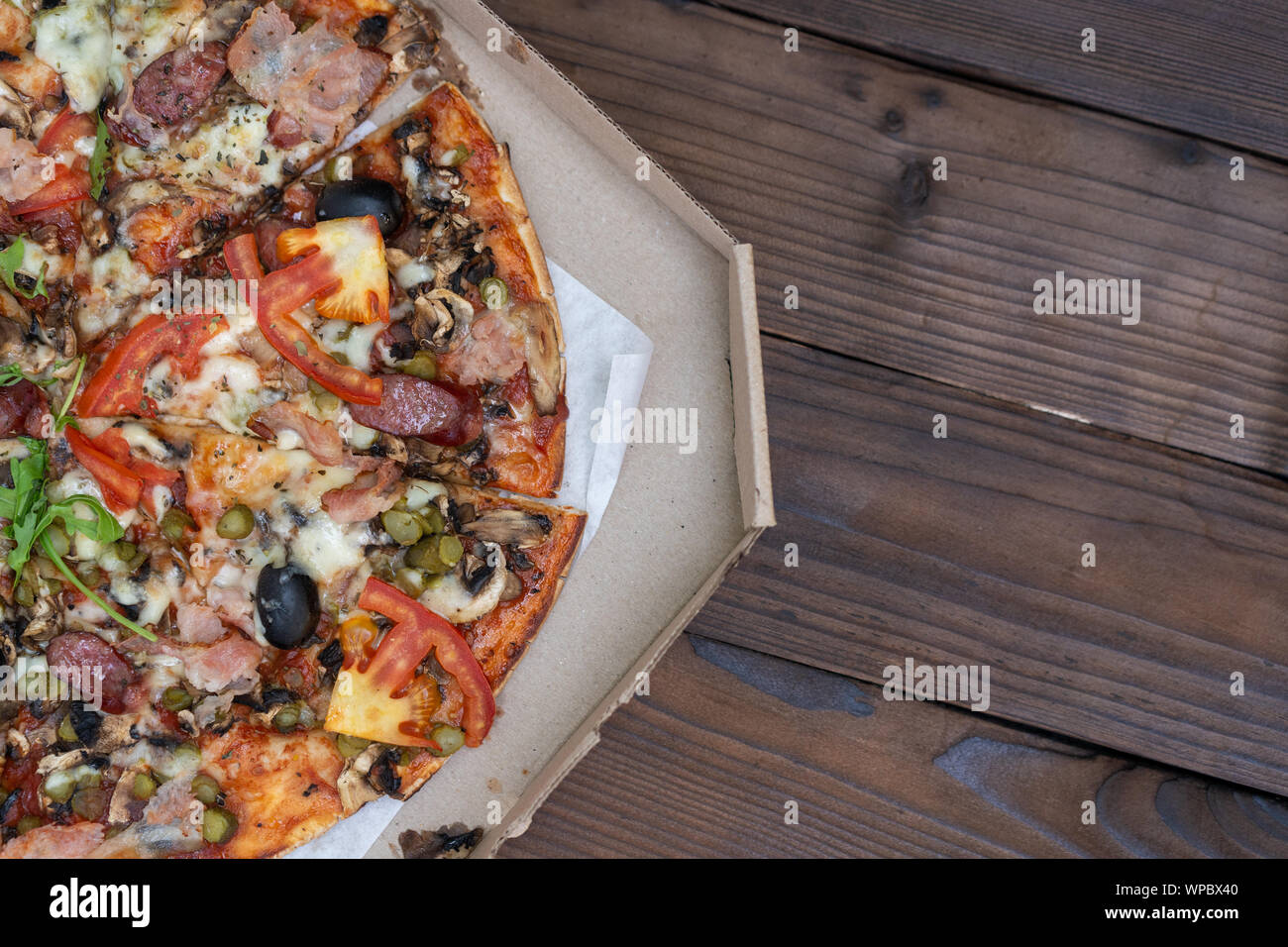Appetizing pizza with smoked sausages bacon meat tomato cheese arugula ...