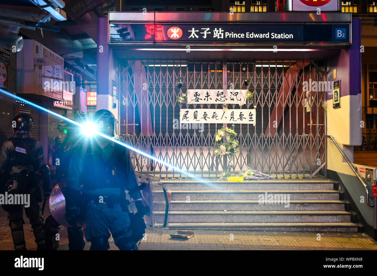Hong Kong, China. 7th Sep 2019. Riot police shine a flashlight outside ...