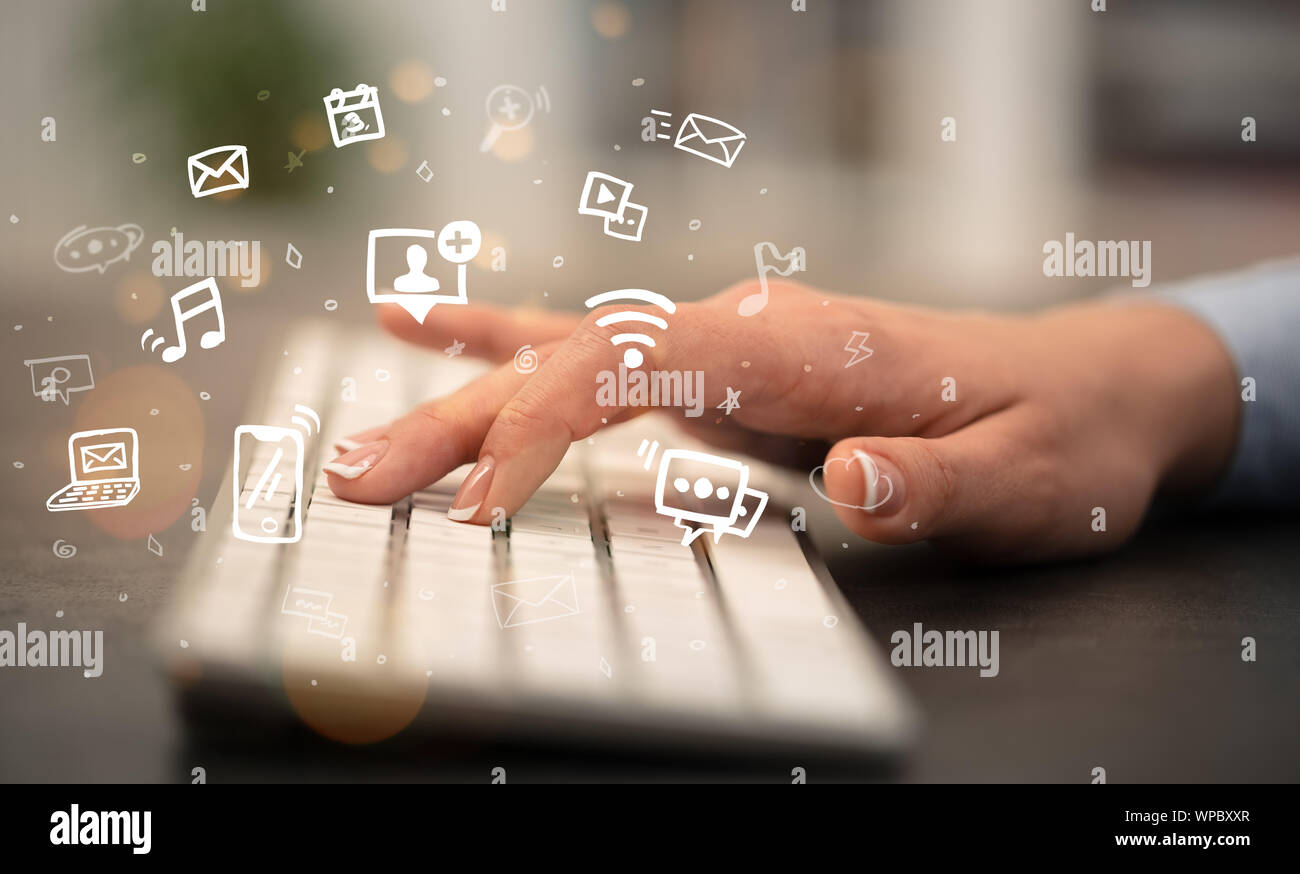 Business woman hand typing on keyboard with drawn application icons ...
