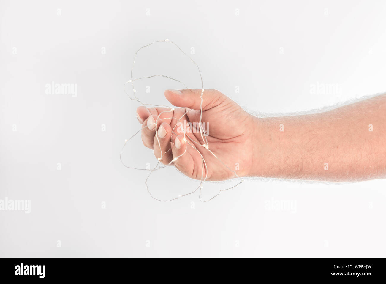 Hand entangled by a cable with many small lights on a white background ...