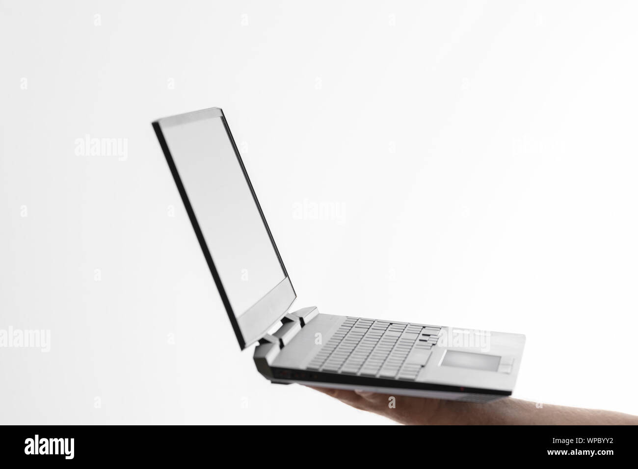Portable computer held by a hand on a white background with space to ...