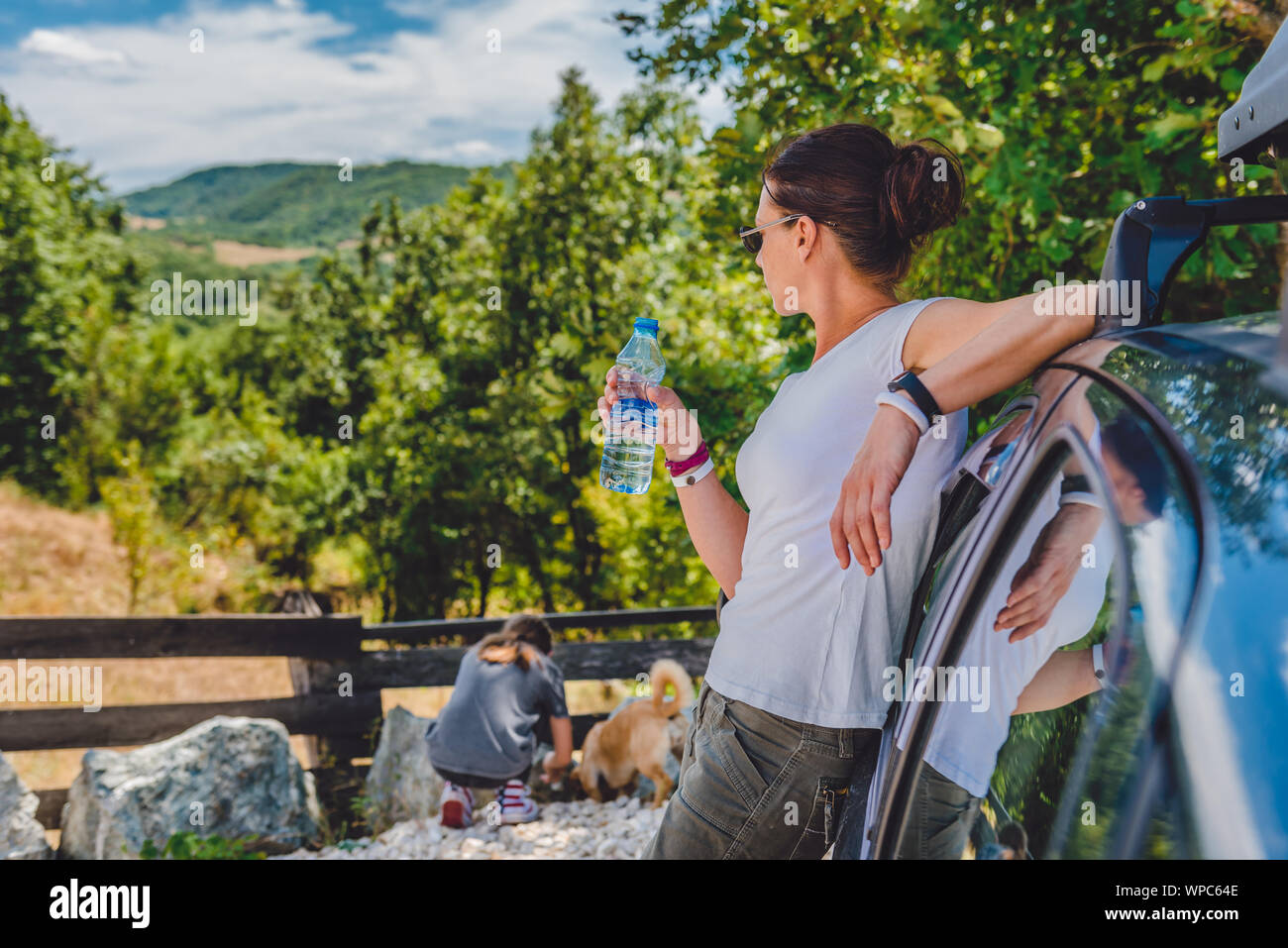 Family on a road trip taking a break to stretch legs after driving ...