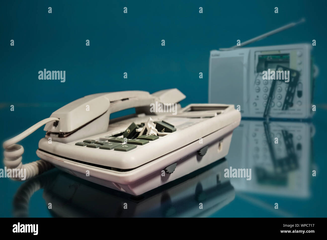 On a glass surface, a earth-line telephone and a portable radio ...