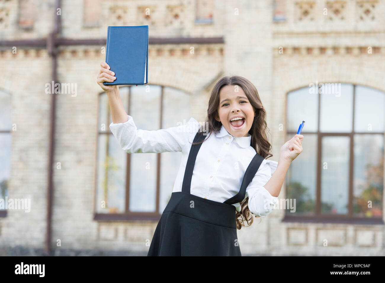 Hooked on learning. Cute smiling child hold book. Pass test ...