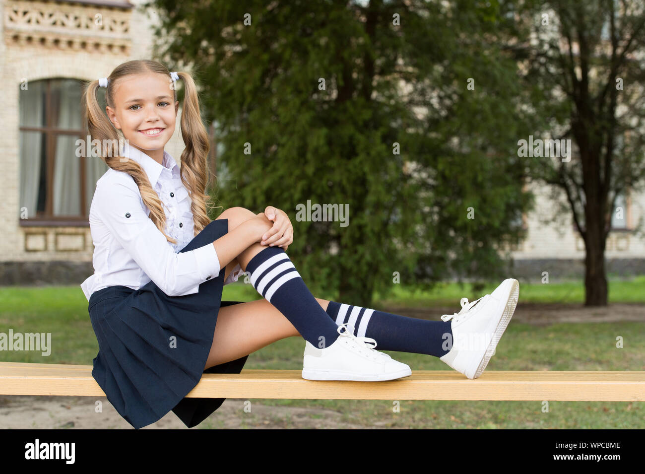 Pleasant minutes of rest. Relaxing in school yard. Perfect schoolgirl ...