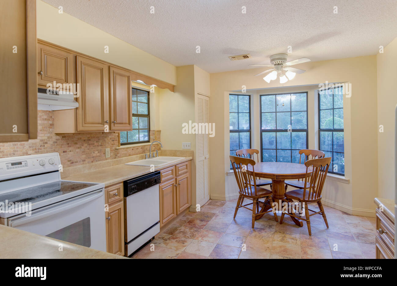 Simple style kitchen with round eat in table Stock Photo - Alamy