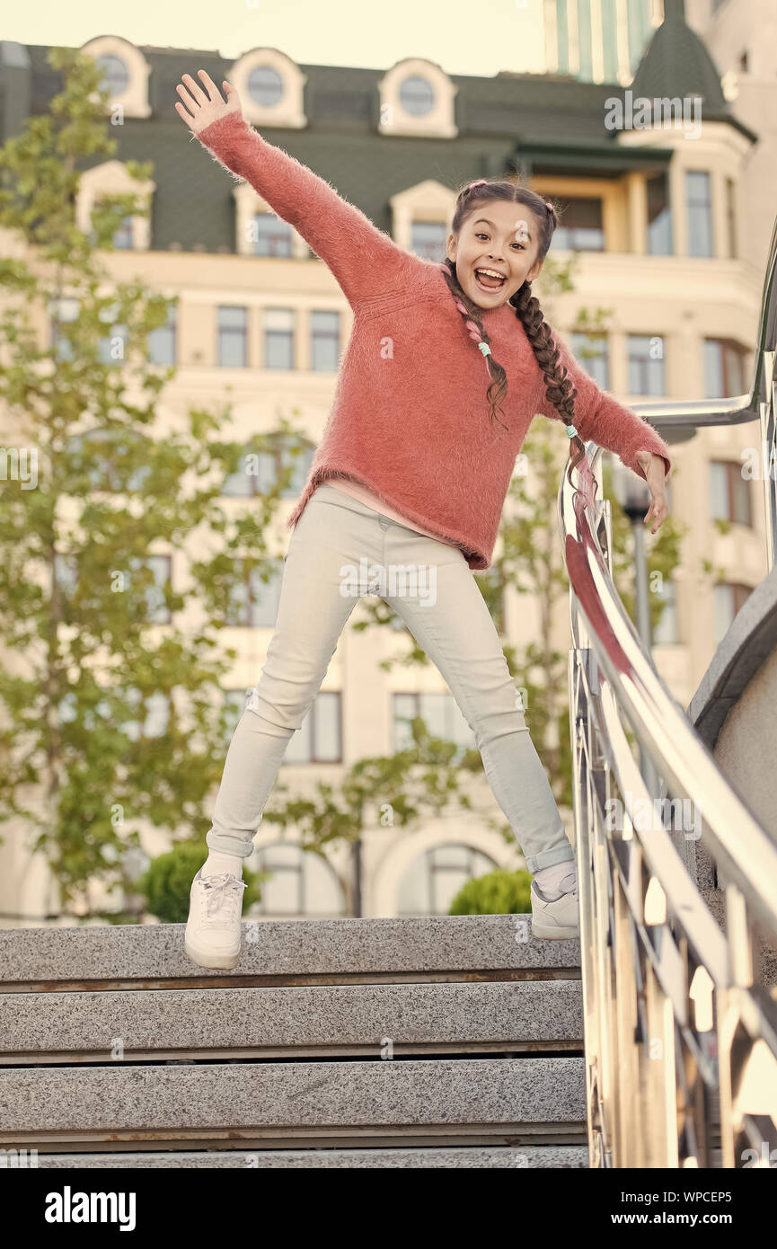 Running down the stairs. Happy energetic kid jumping on steps in casual ...
