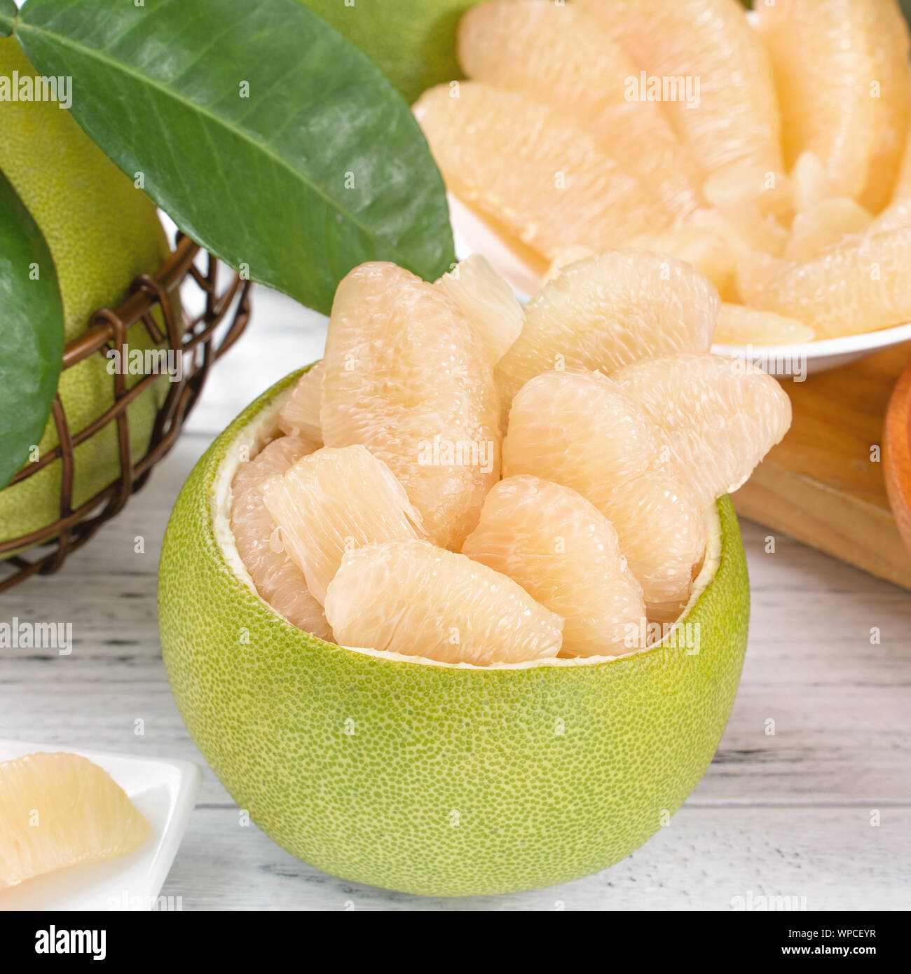 Fresh peeled pomelo, grapefruit, shaddock on bright wooden table ...