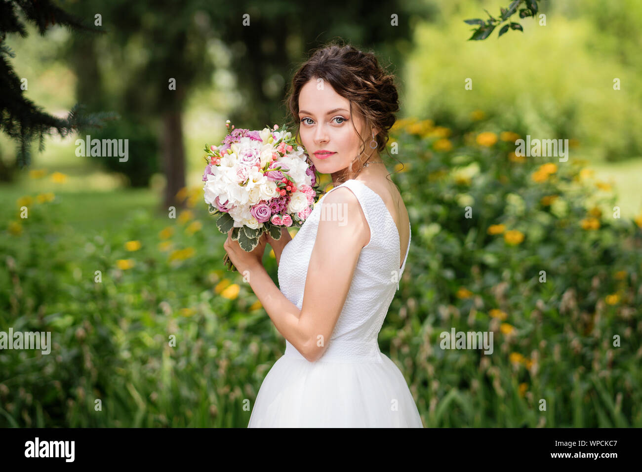 Beautiful bride in fashion wedding dress on natural background. The ...
