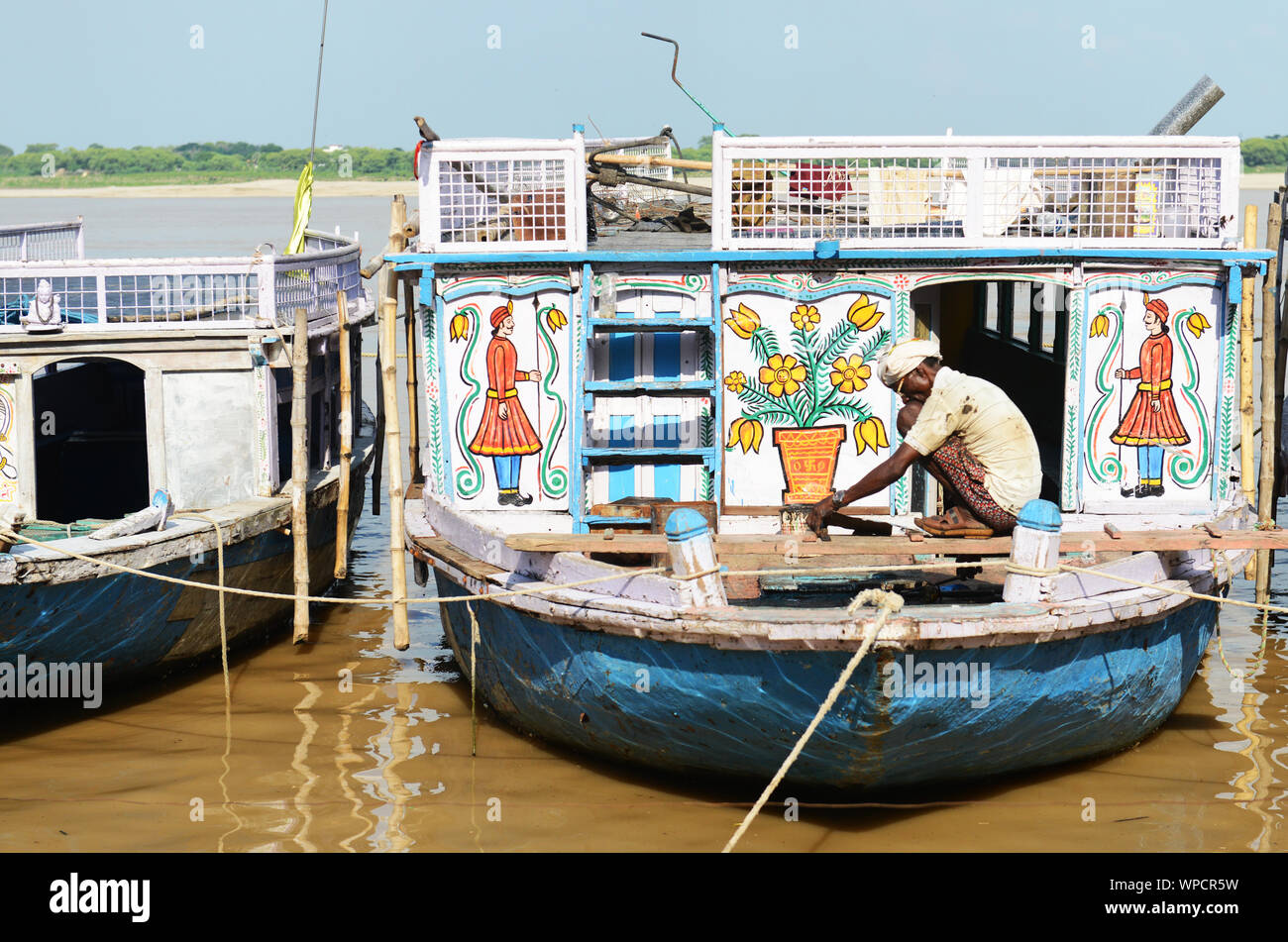 A colorful boat tied to the Ganges riverbank in Varanasi, India Stock ...