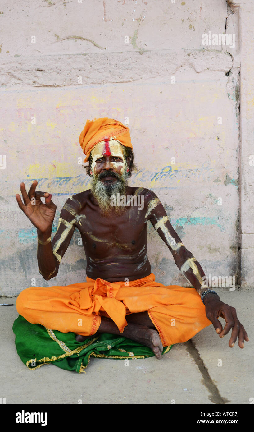 A Vaishnava sadhu sitting on the Ghats by the Ganges river in Varanasi ...