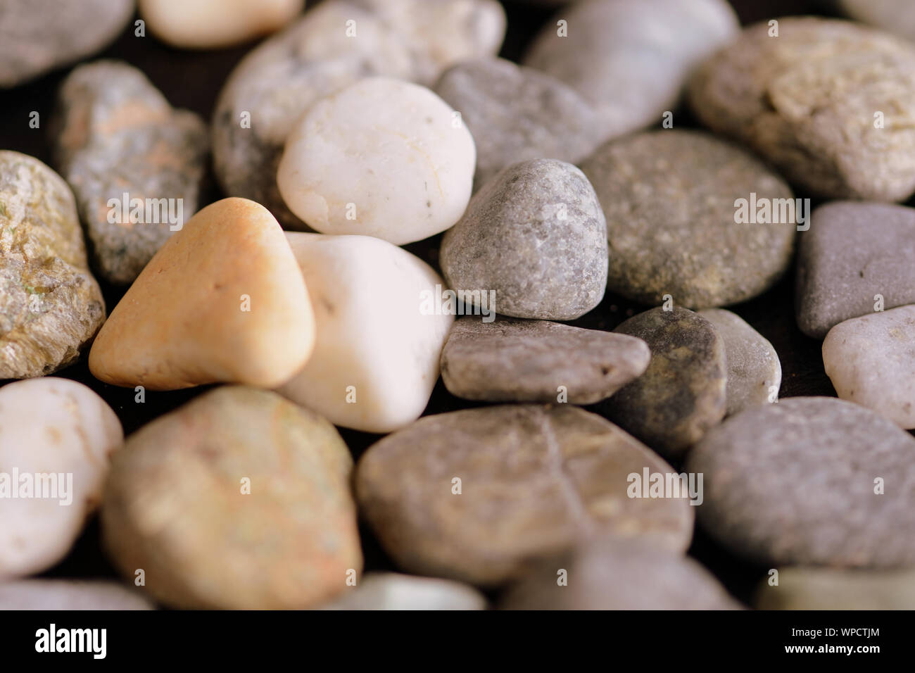 Scattered pebble stones on a dark background close up Stock Photo - Alamy