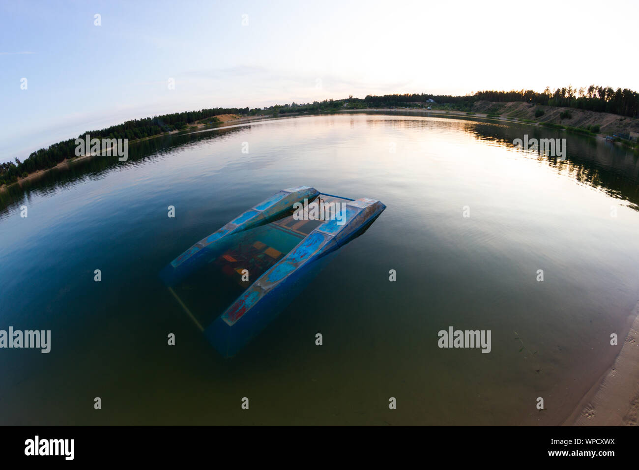 Sinking catamaran in lake. Old blue catamaran Stock Photo - Alamy