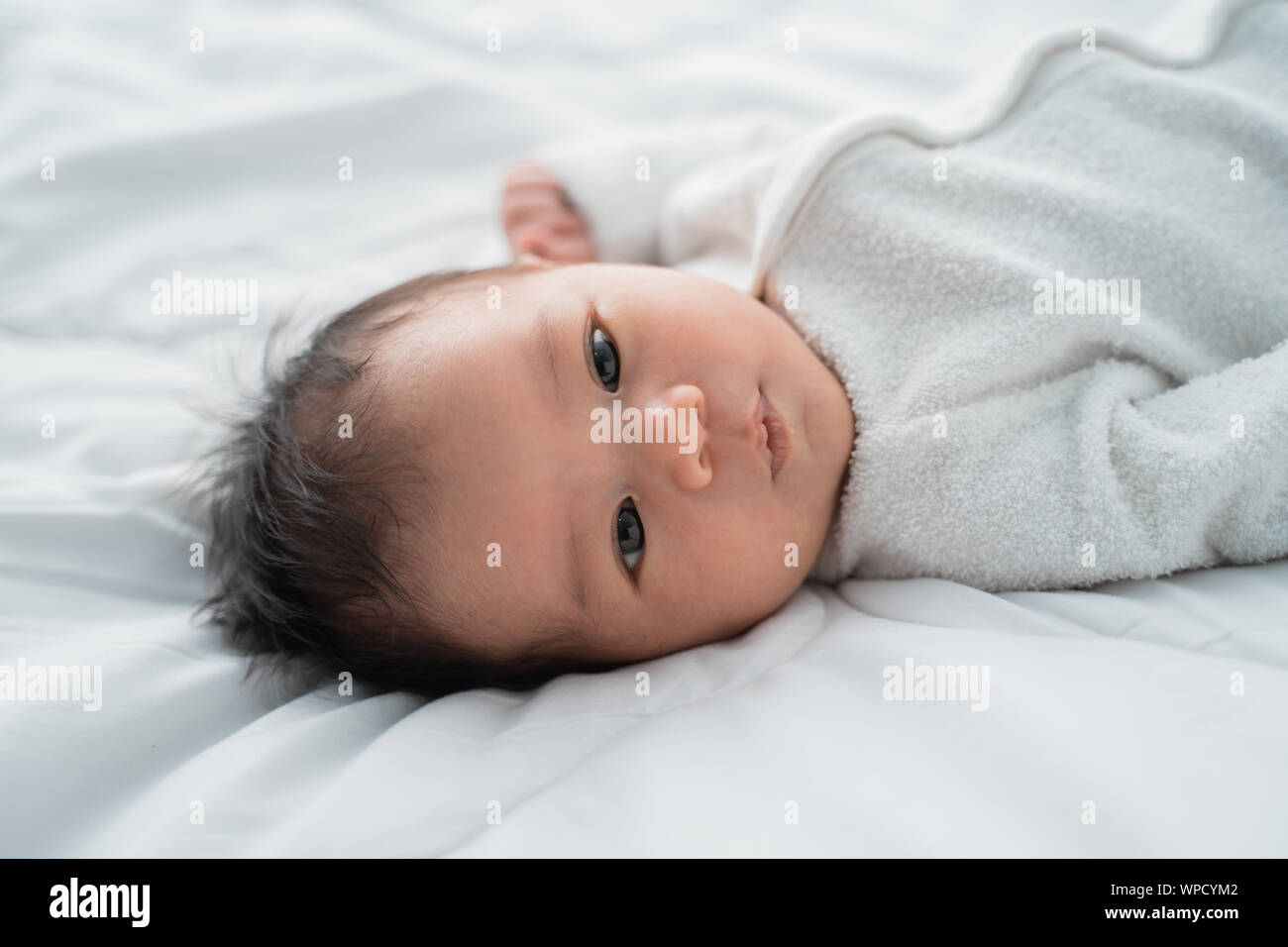 infant newborn baby on white bed Stock Photo - Alamy