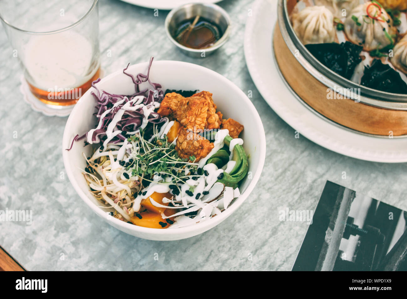 Pan-Asian food - different dim sums in bamboo bowl and salad. Lunch for ...