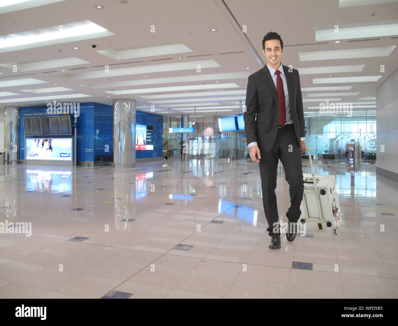 Businessman pulling suitcase in an airport terminal Stock Photo - Alamy