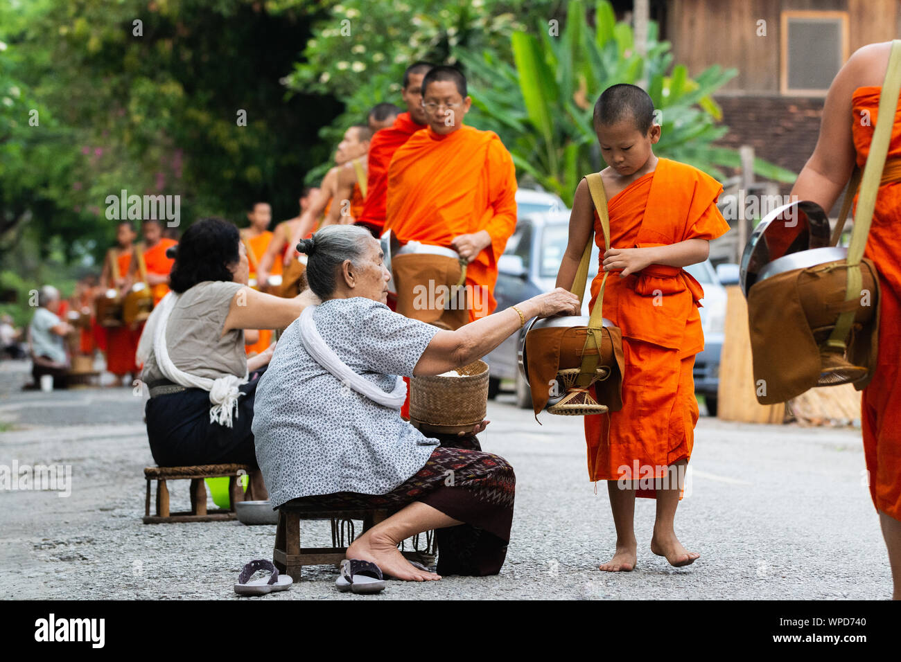 Luang Prabang, Laos - May 2019: Laotian people making offerings to ...