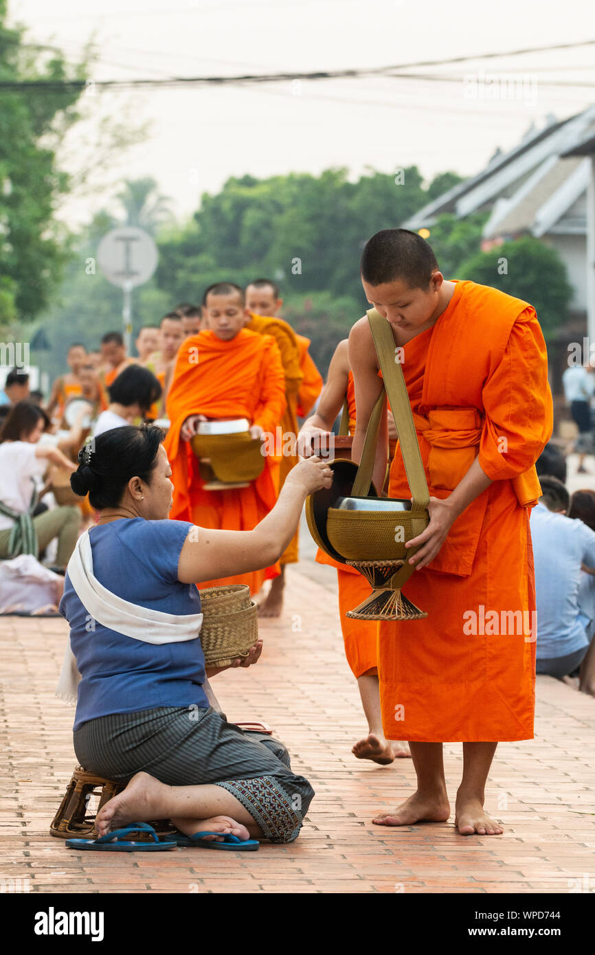 Luang Prabang, Laos - May 2019: Laotian people making offerings to ...