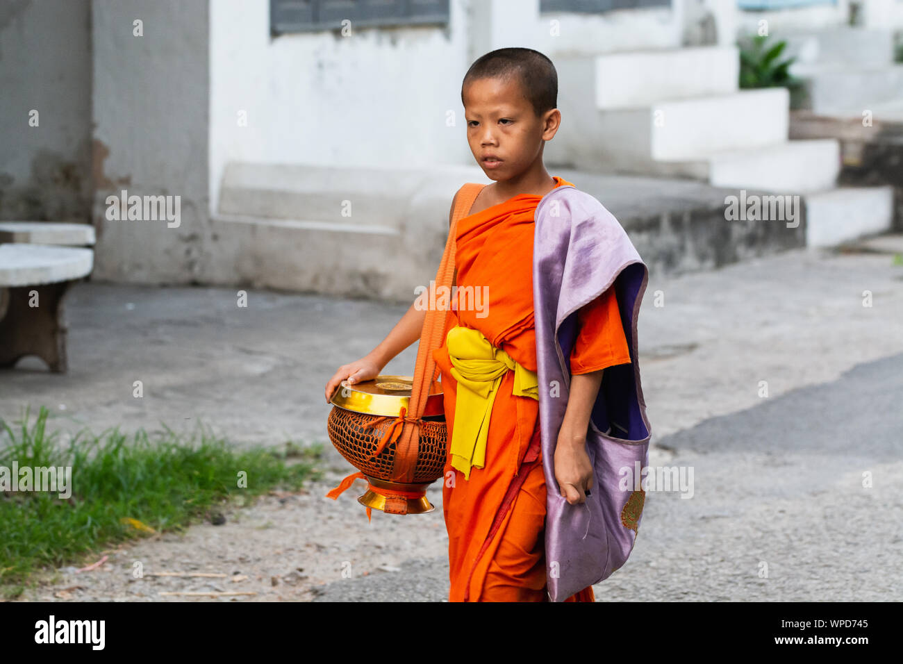 Luang Prabang, Laos - May 2019: Laotian Buddhist monk walking along the ...