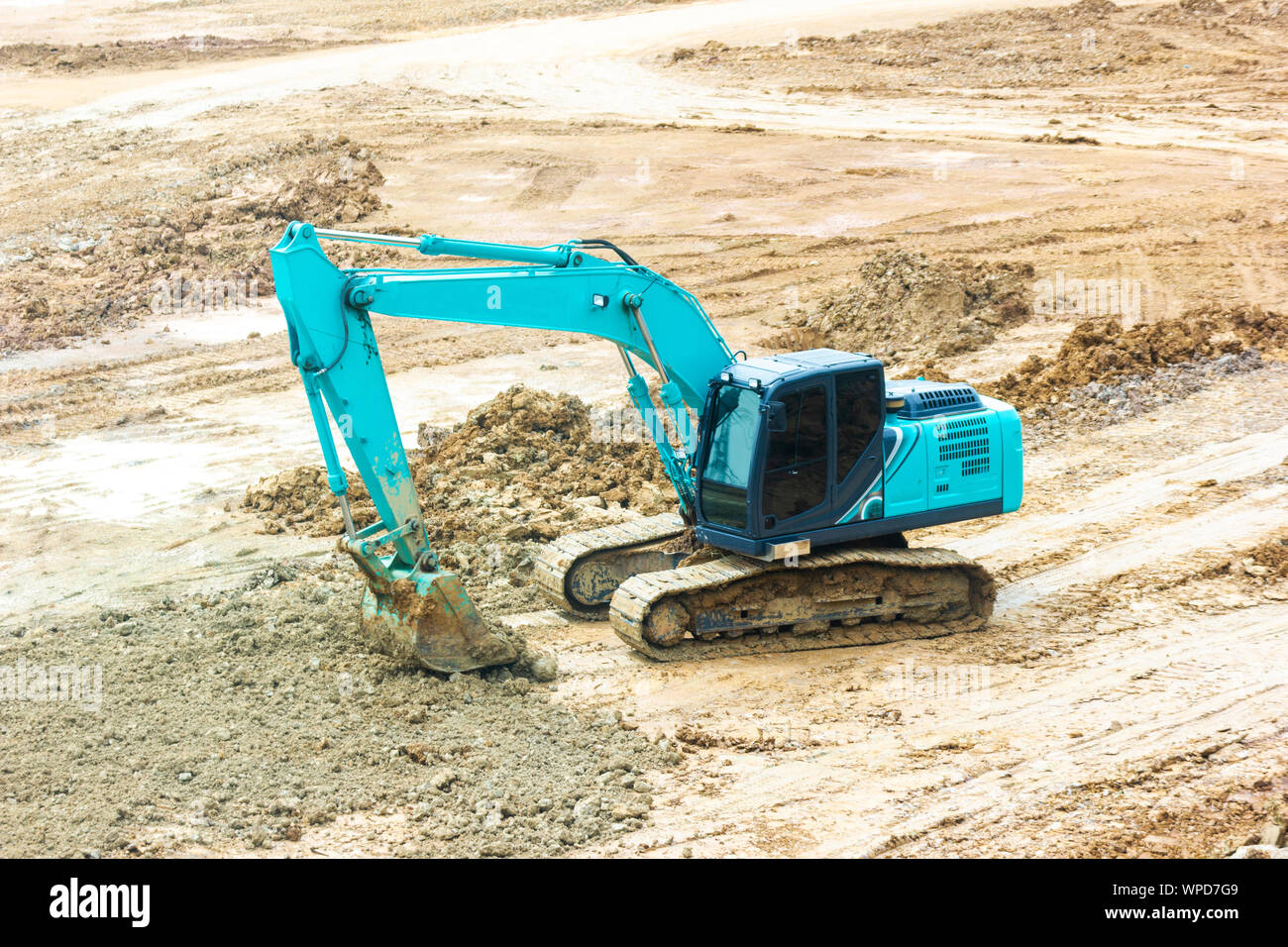 Green mini Crawler excavator hydraulicis digging a hole concrete and ...