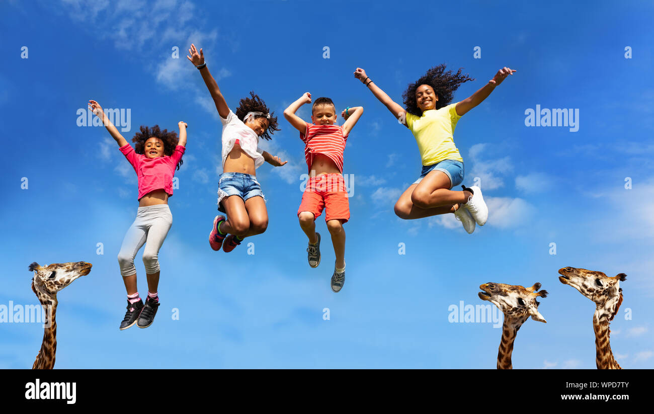 Happy kids group jump higher than head of giraffes Stock Photo - Alamy