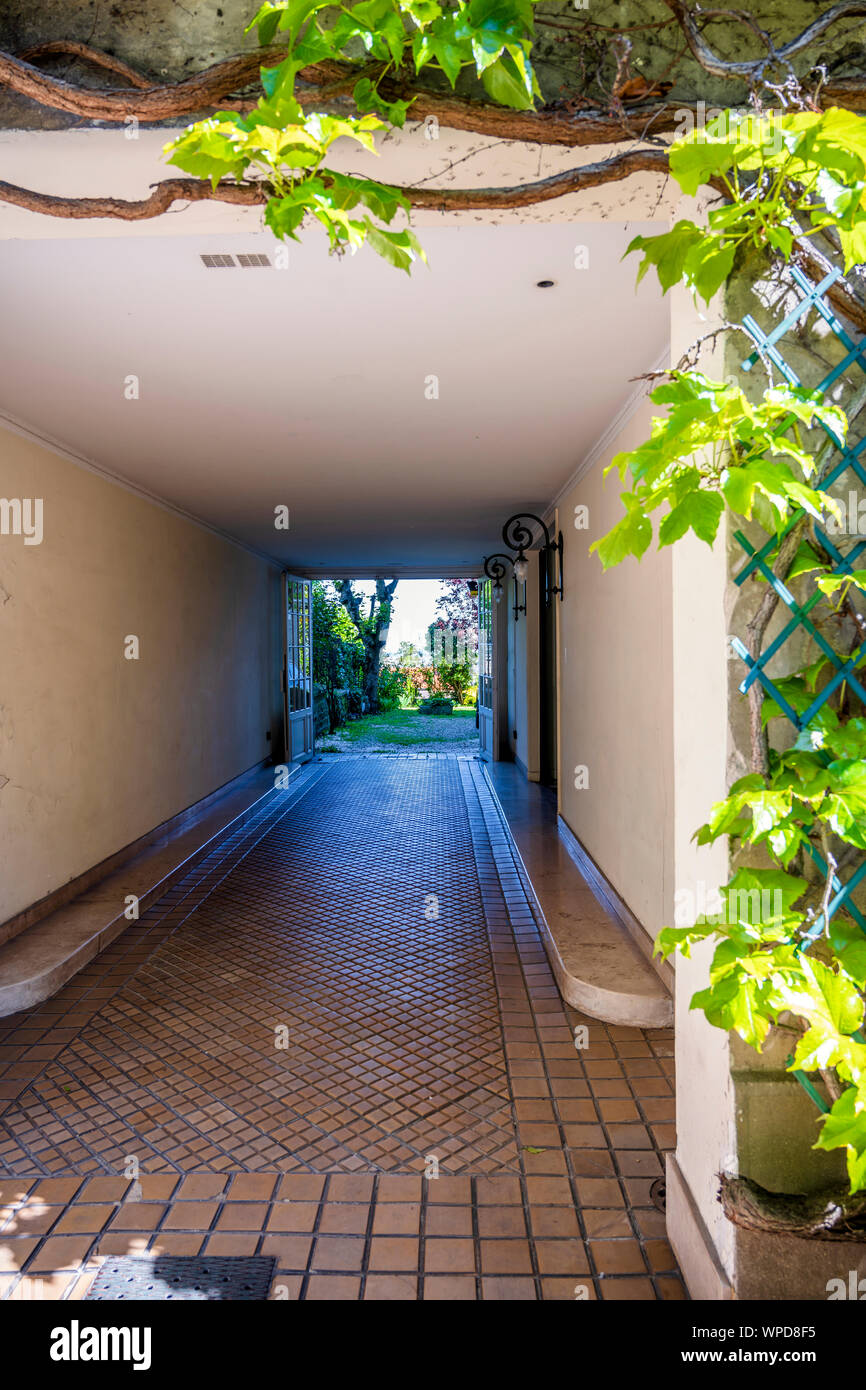 A rectangular arched passage through the building to the backyard of a ...