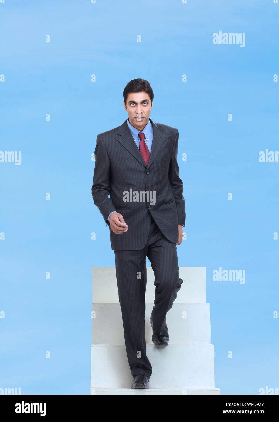 Businessman walking down staircase Stock Photo - Alamy