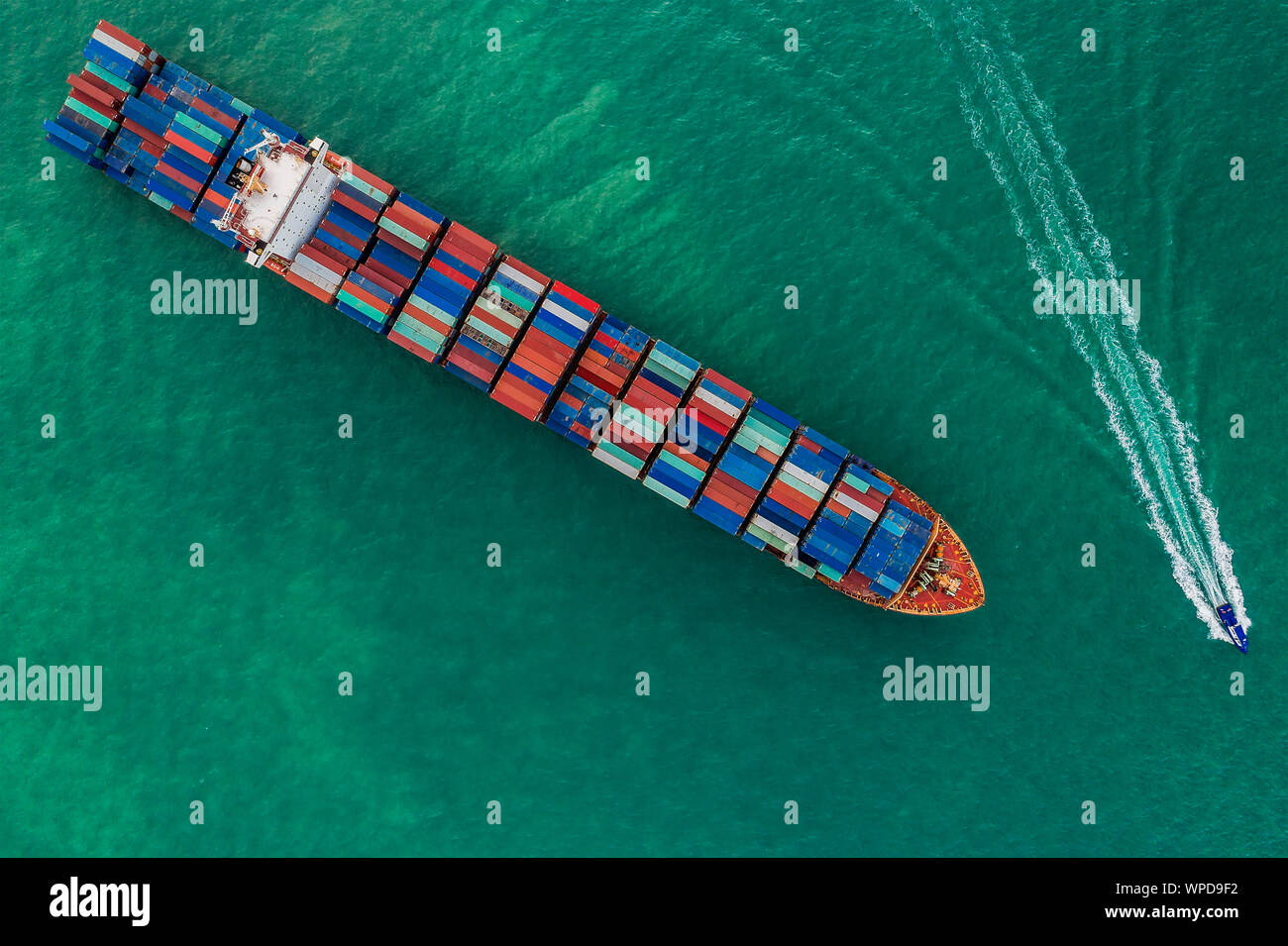 a cargo ship carrying multi-stack of containers in sea crossing ...