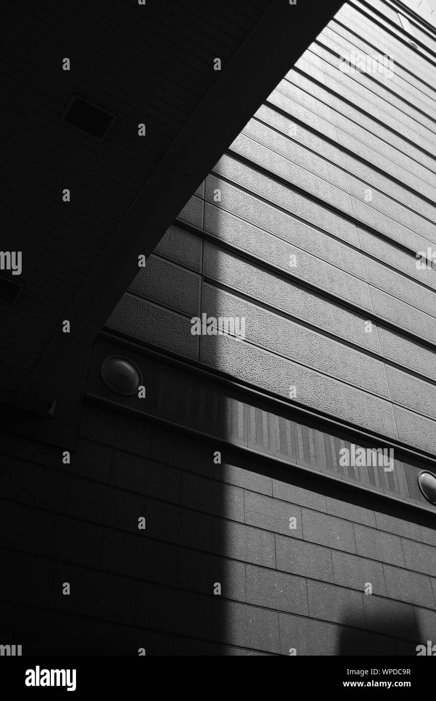 Vertical grayscale shot of a top near a brick wall of a building Stock ...