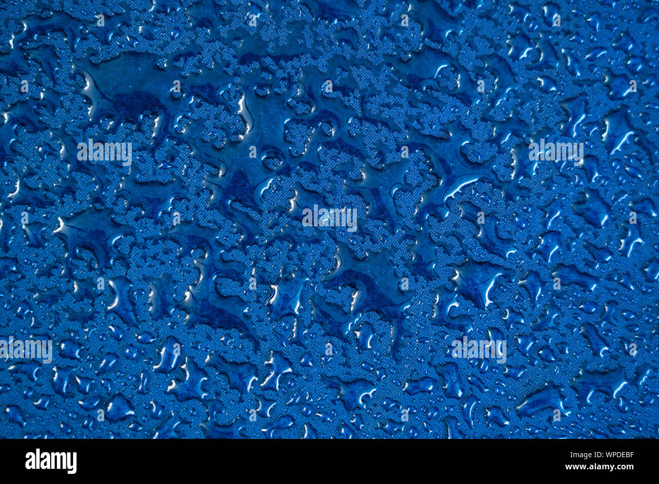 View texture blue synthetic waterproof clothing.Water drops on ...