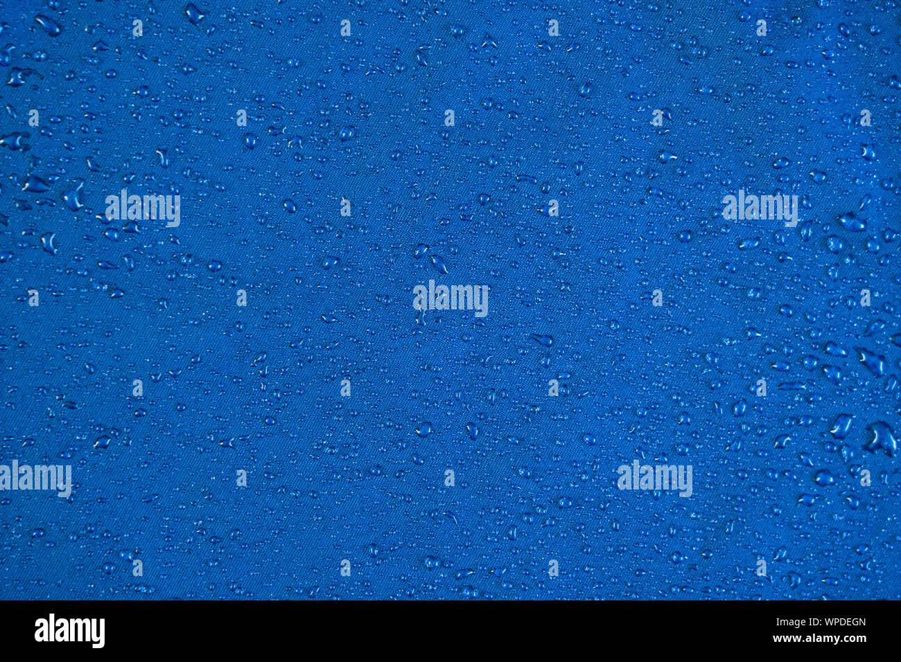 View texture blue synthetic waterproof clothing.Water drops on ...