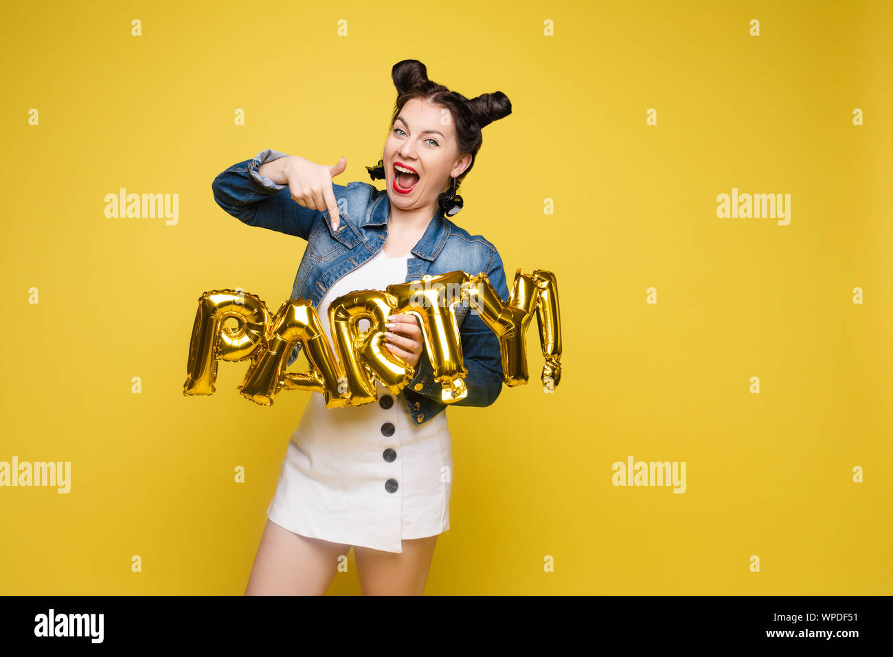 Attractive happy woman laughing holding big gold letters posing at ...