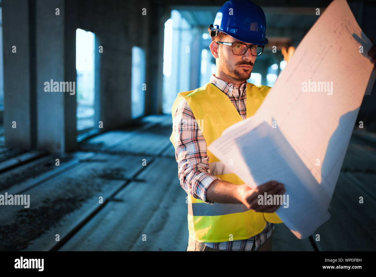 Picture of construction site engineer looking at plan Stock Photo - Alamy