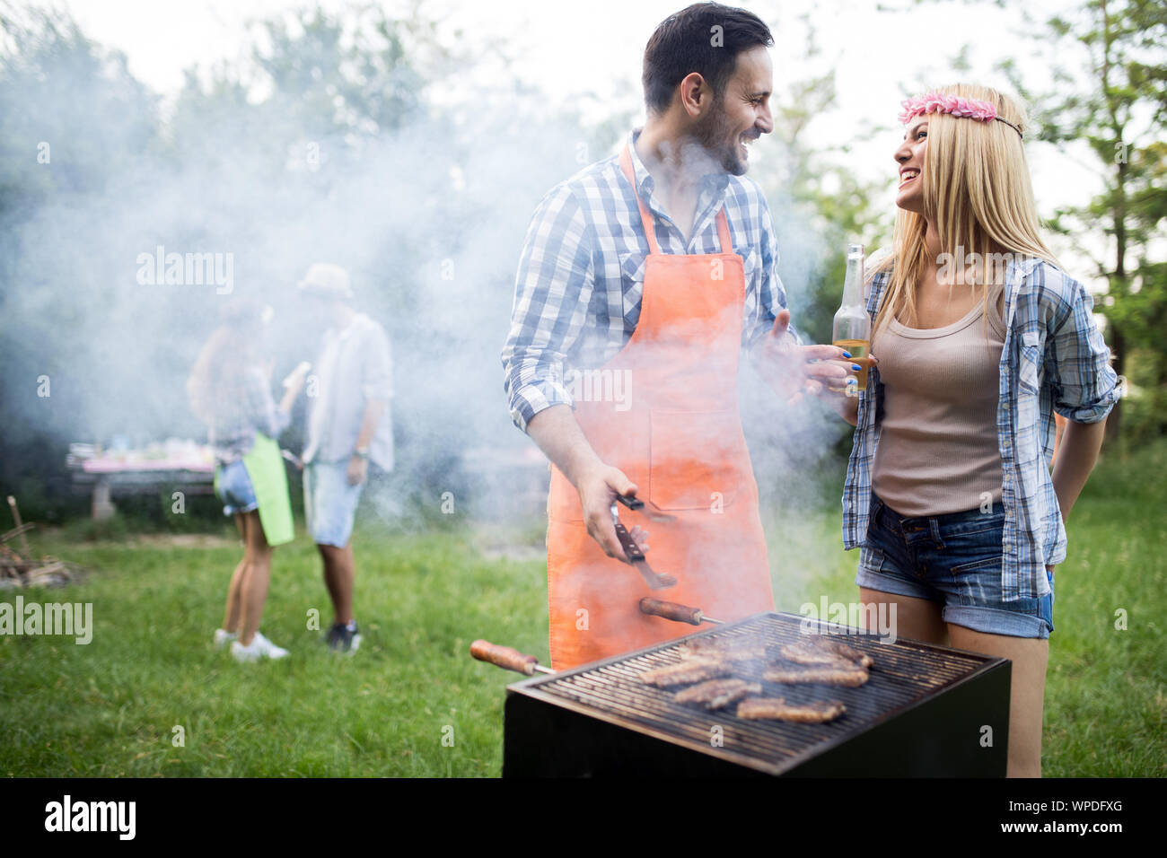 Group of friends making barbecue in the nature Stock Photo - Alamy