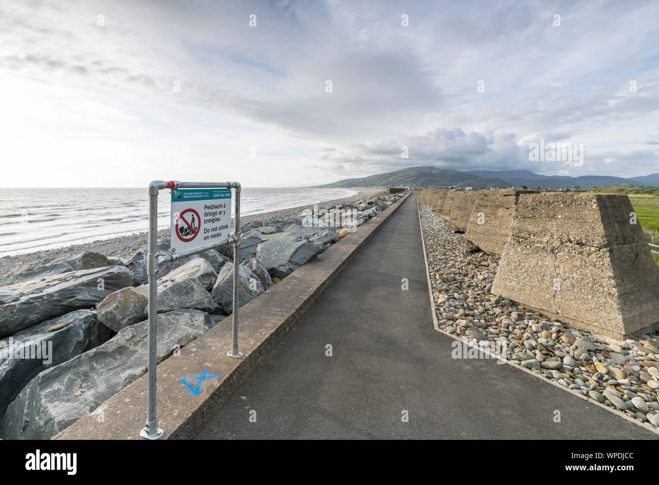 Do not climb on the rocks warning sign on Fairbourne beach Gwynedd in ...