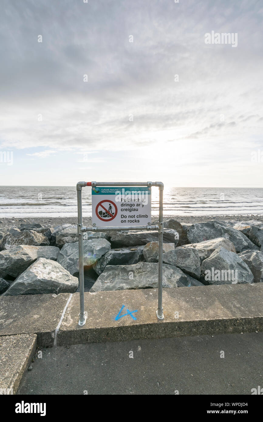 Do not climb on the rocks warning sign on Fairbourne beach Gwynedd in ...