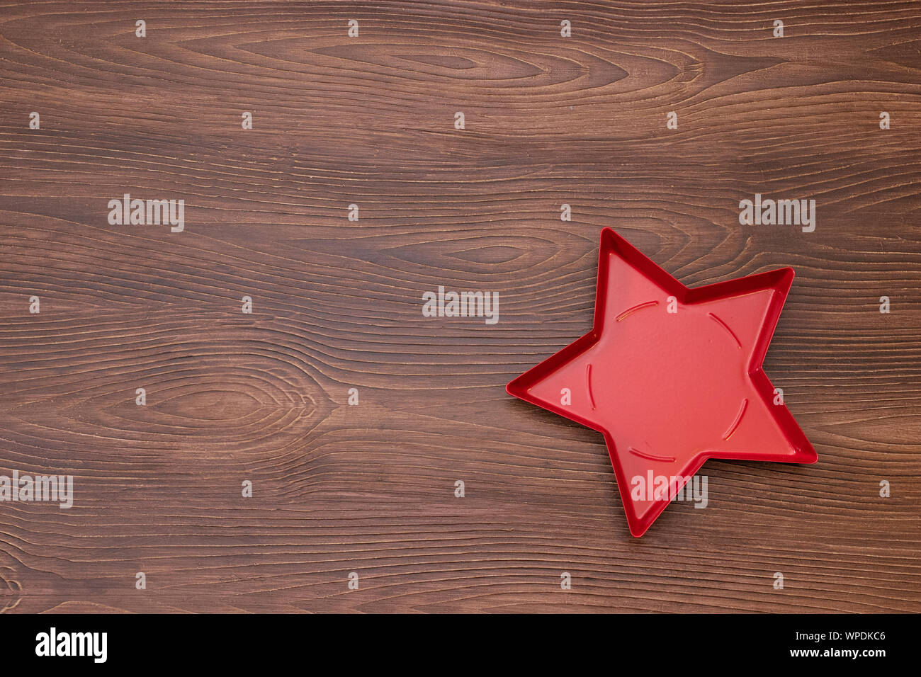 red colored star shaped plates on isolated wooden background, food ...