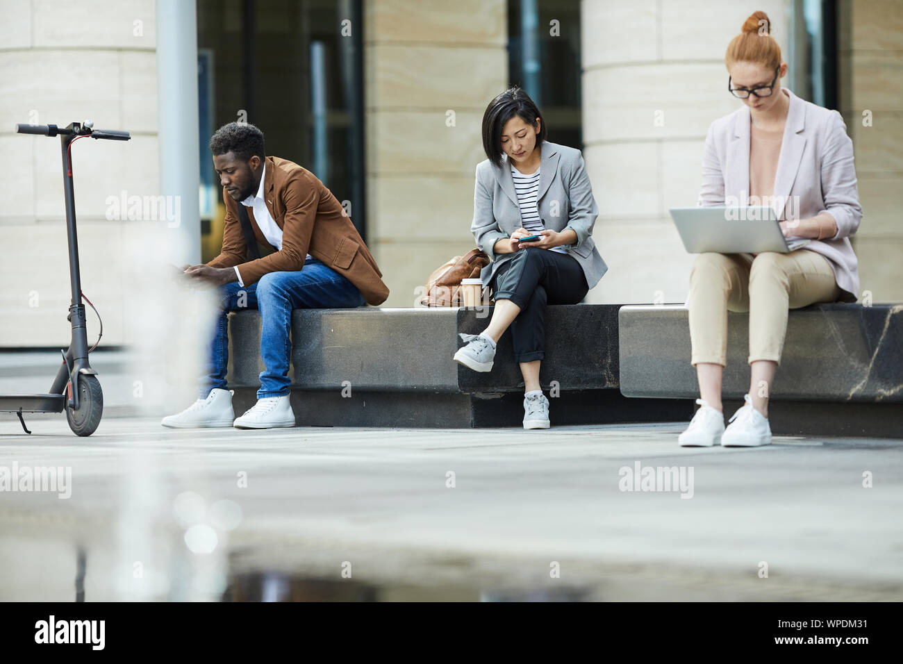 Full length portrait of contemporary young people using electronic ...