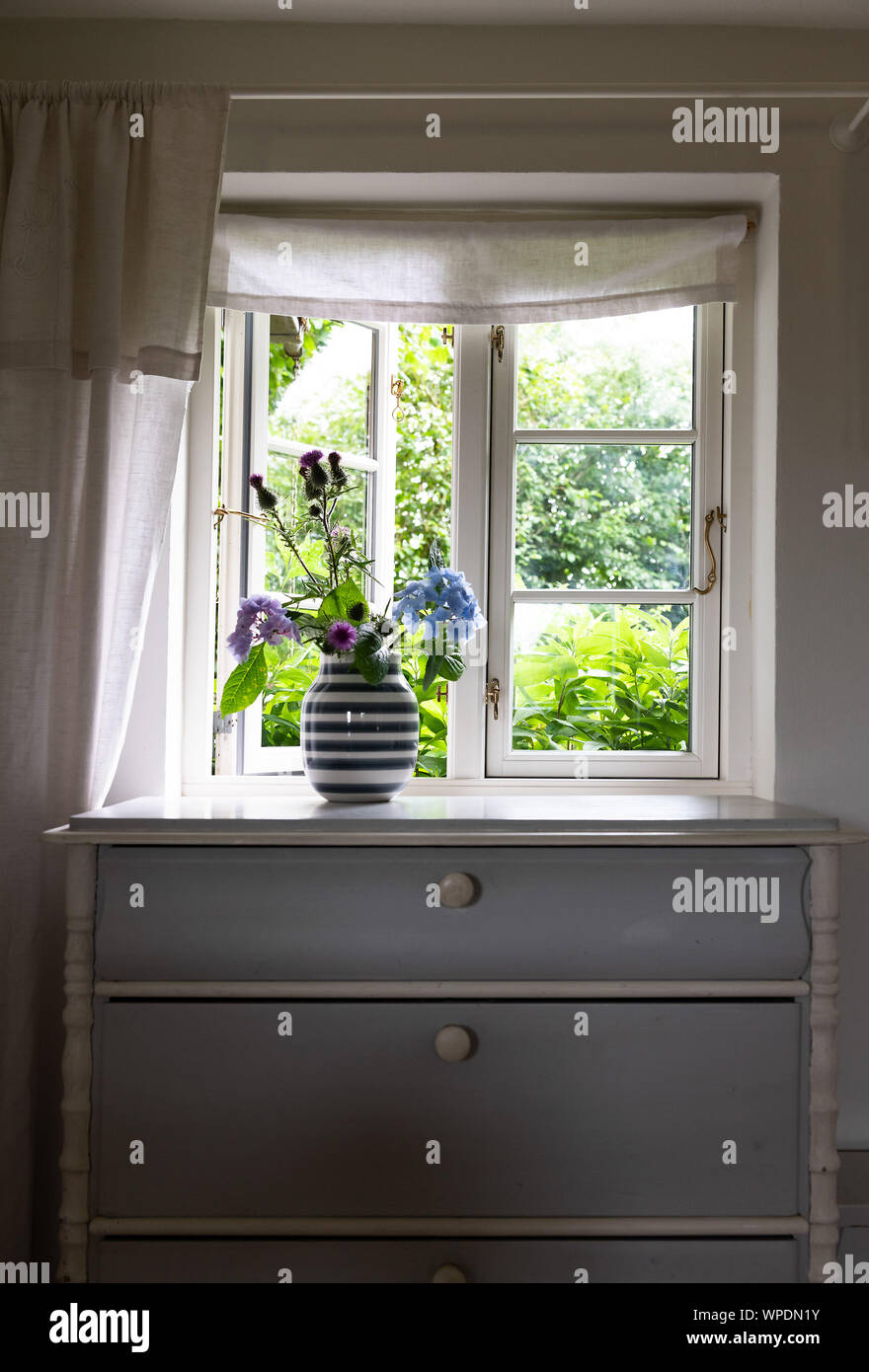 Window inside country house with flower vase on chest of drawers Stock ...