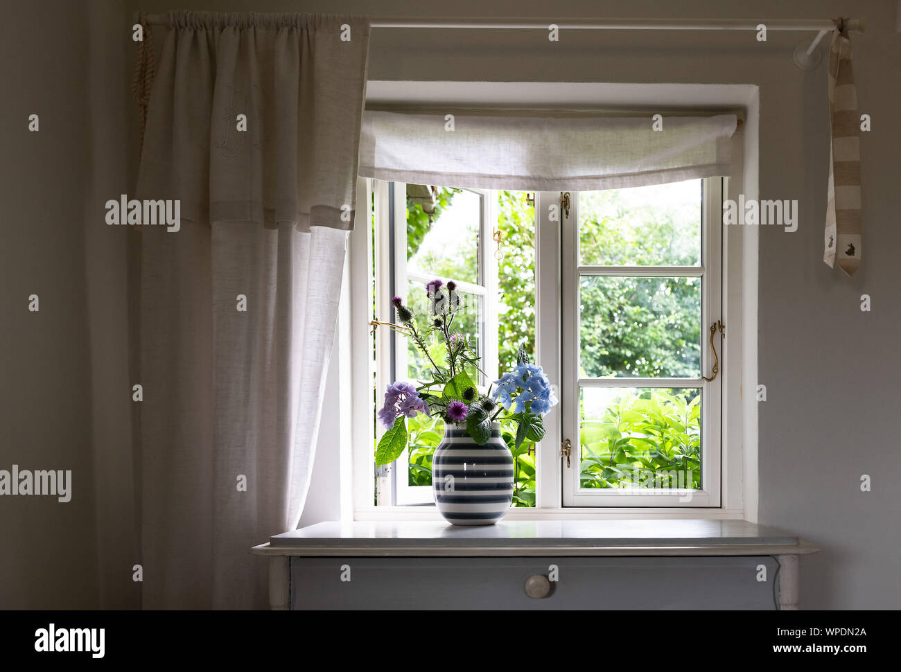 Window inside country house with flower vase on chest of drawers Stock ...